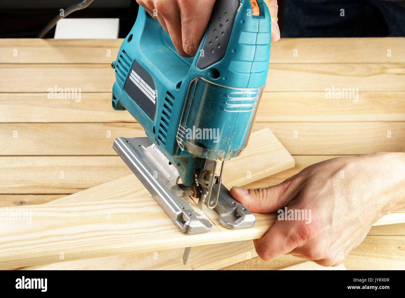 man carpenter builder working with electric jigsaw and wood, on wooden ...
