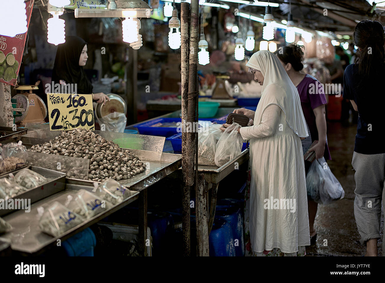 Muslim woman shopping in a Thailand indoor market wearing a traditional ...