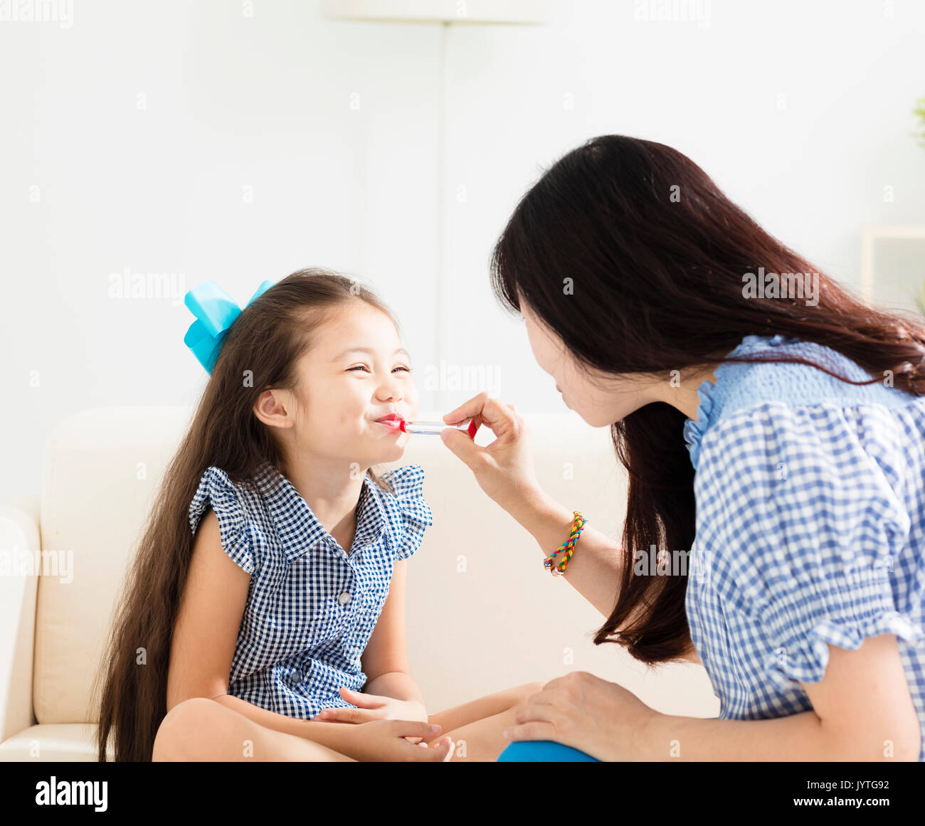 Little girl playing makeup with mothers Stock Photo - Alamy