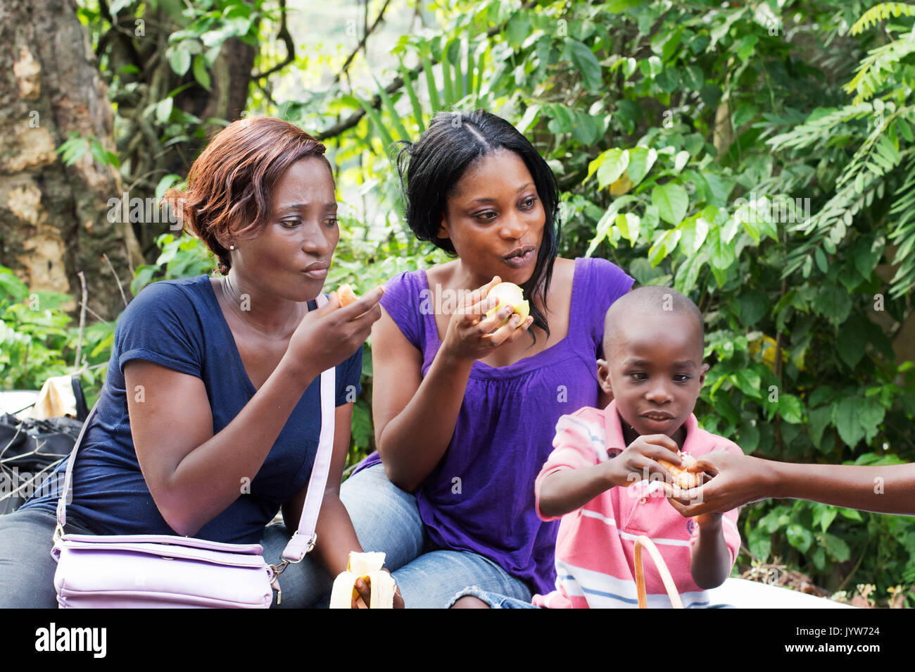 campers seated on a piece of linen, share fruit Stock Photo - Alamy
