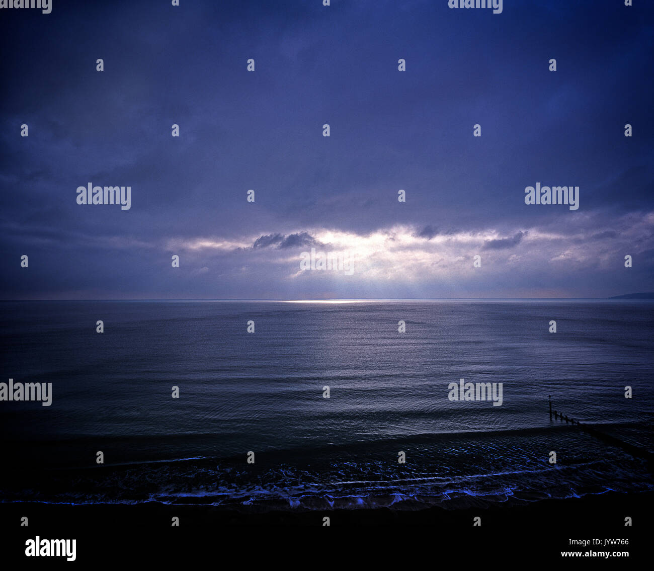 Dark stormy day beach scene with calm sea Stock Photo - Alamy