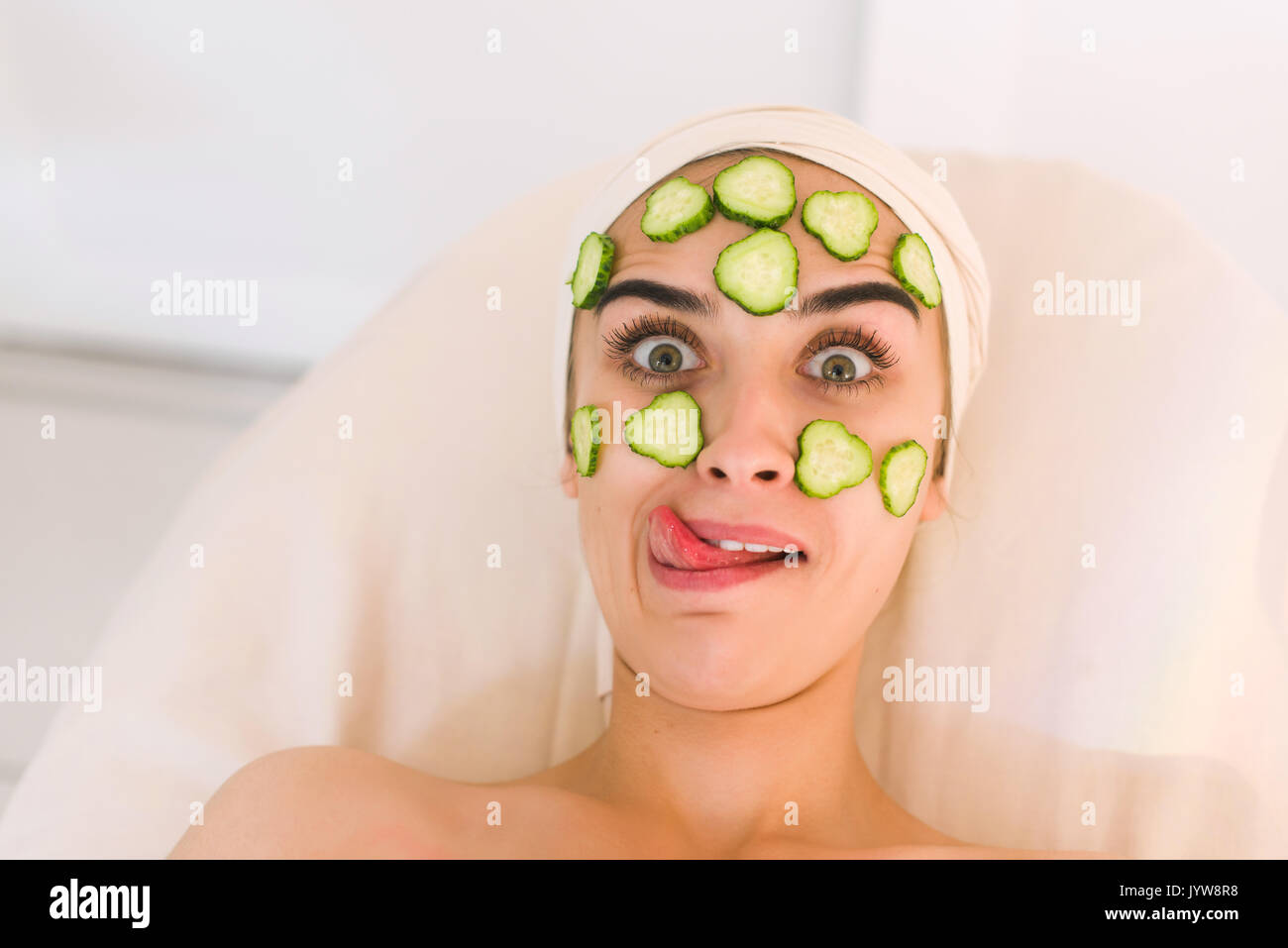 Cucumber slices on eyes. Young woman with facial mask of cucumber in ...