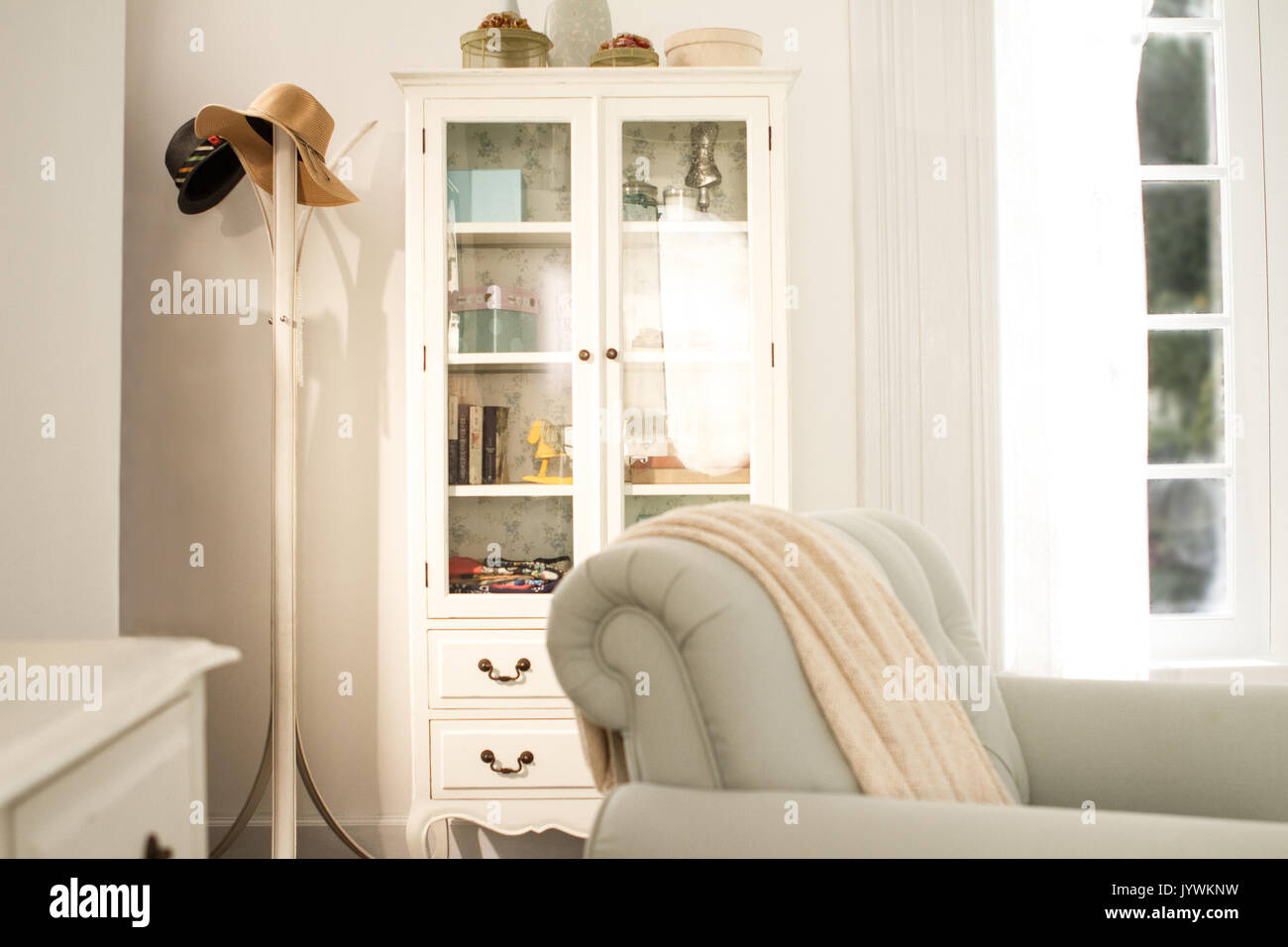 a hanging hat pole put near by a white display sideboard in bedroom ...