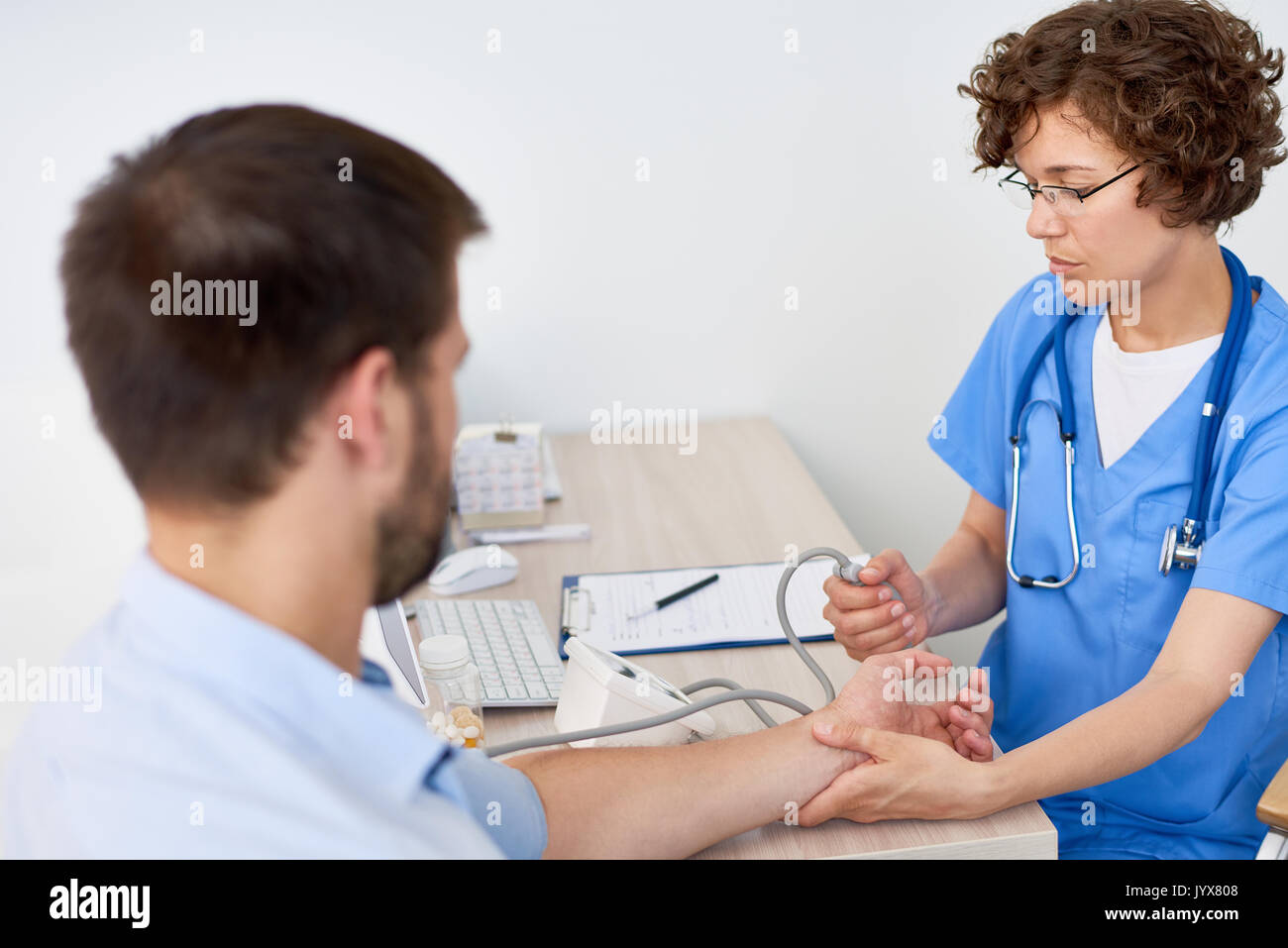 Nurse Measuring Blood Pressure for Patient Stock Photo - Alamy