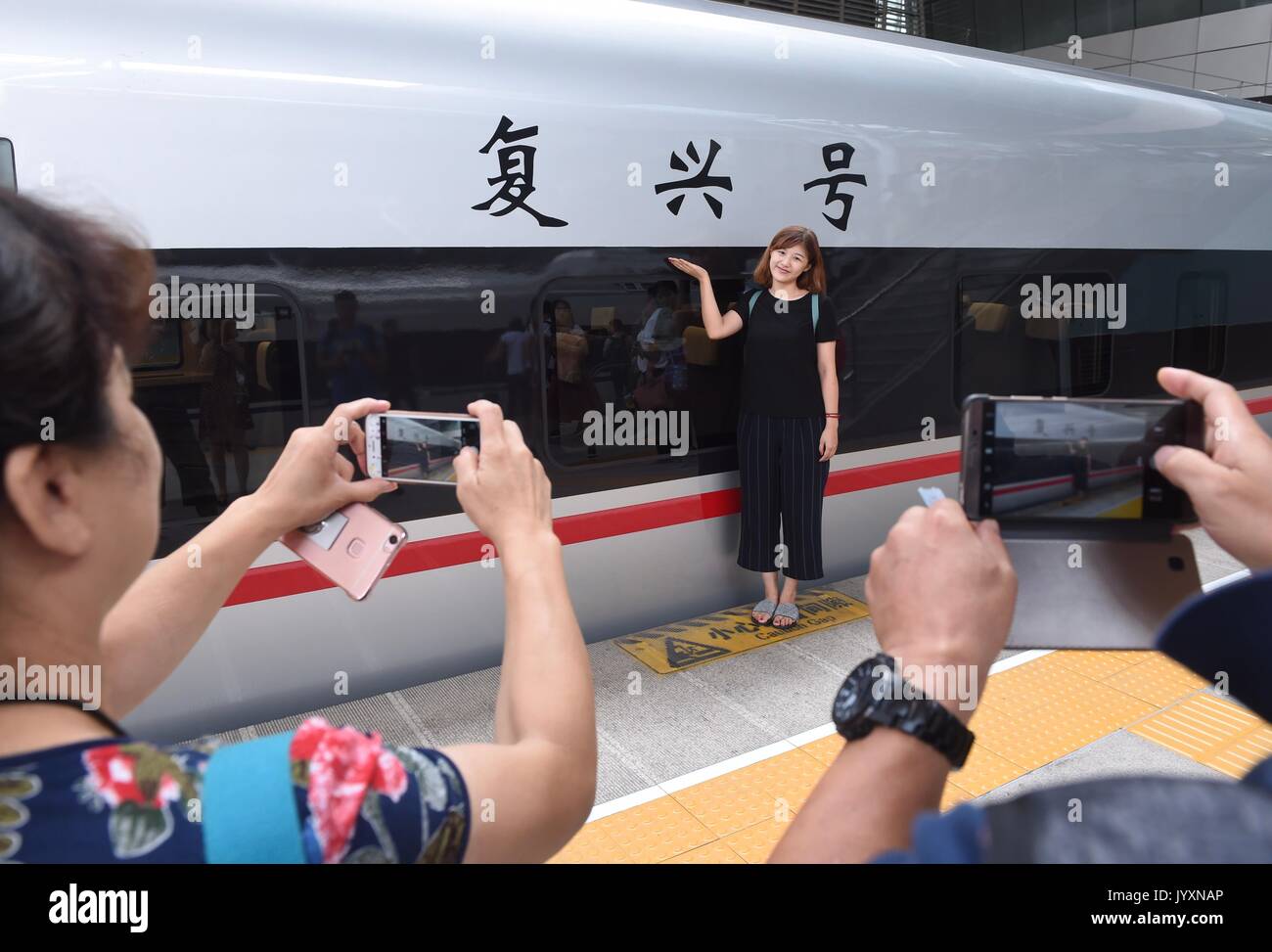 Beijing, China. 21st Aug, 2017. Passengers take photos in front of the ...