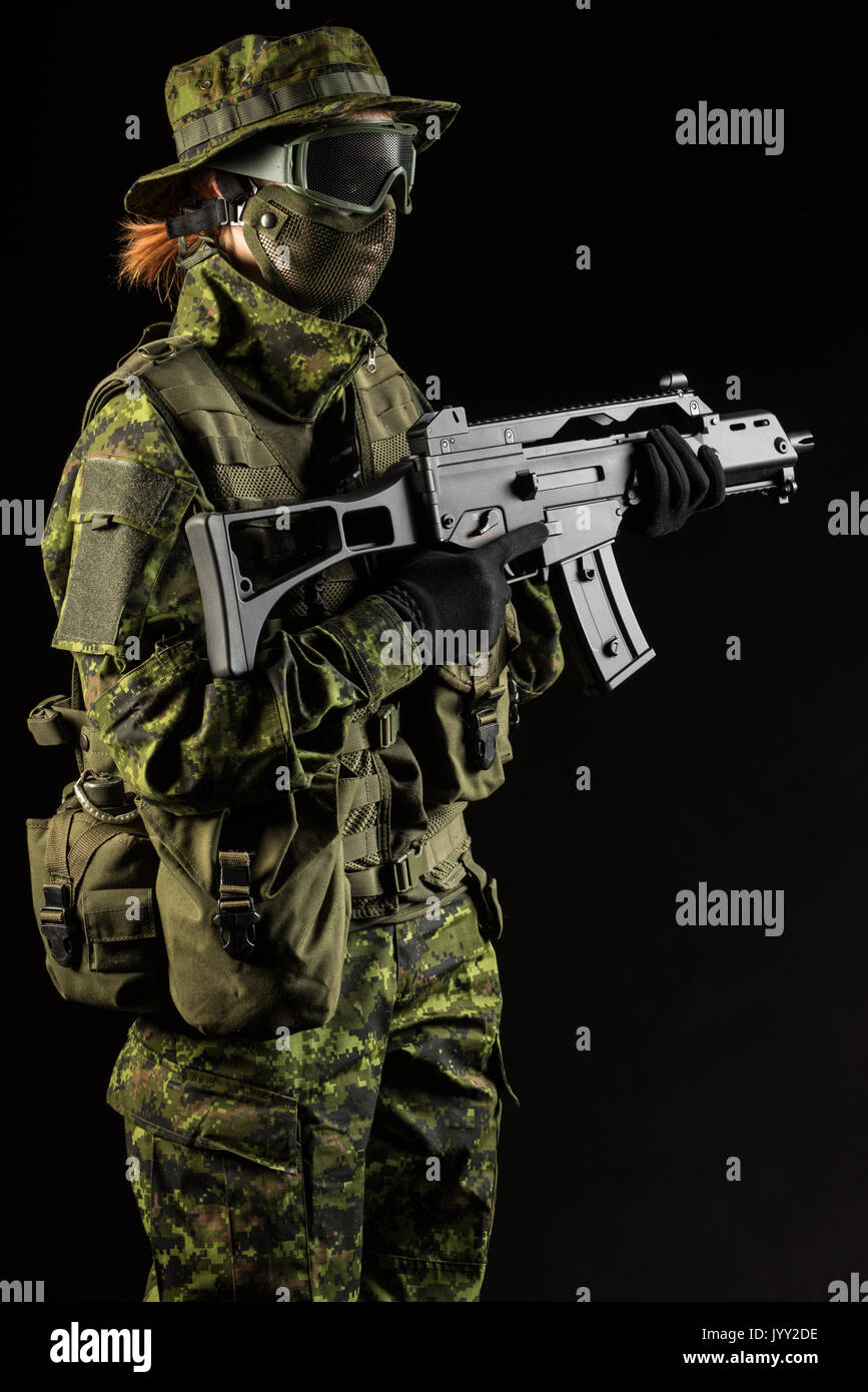 Portrait of armed woman with camouflage. Young female airsoft sniper ...