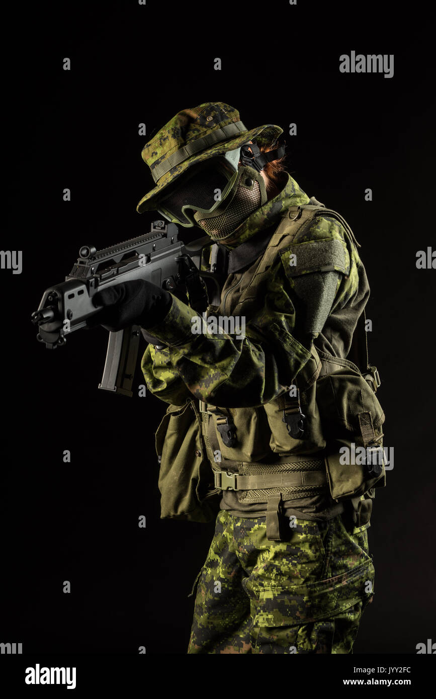 Portrait of armed woman with camouflage. Young female airsoft sniper ...