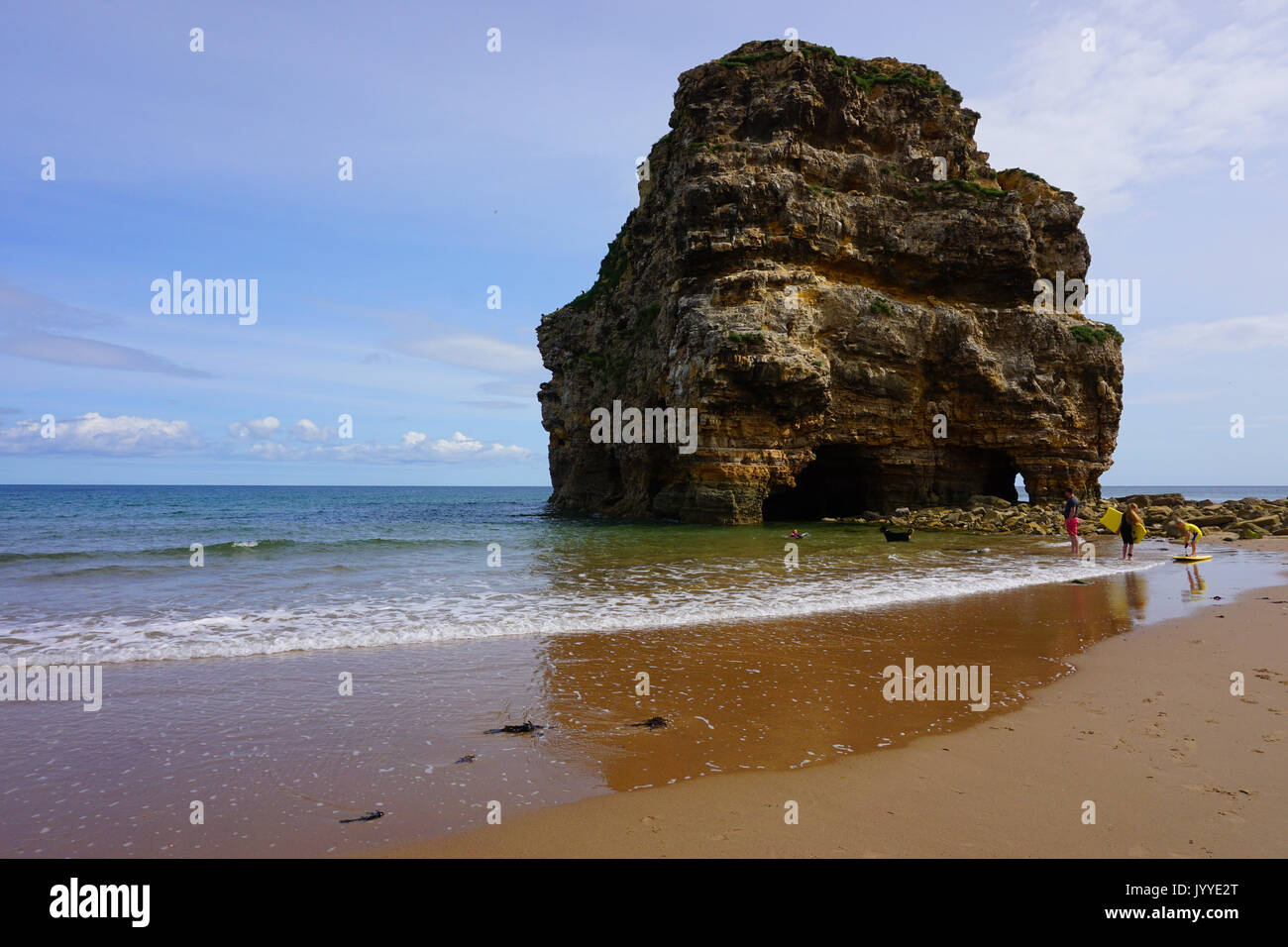 People on the beach at Marsden Rock a Rocky Formation of Limestone off ...