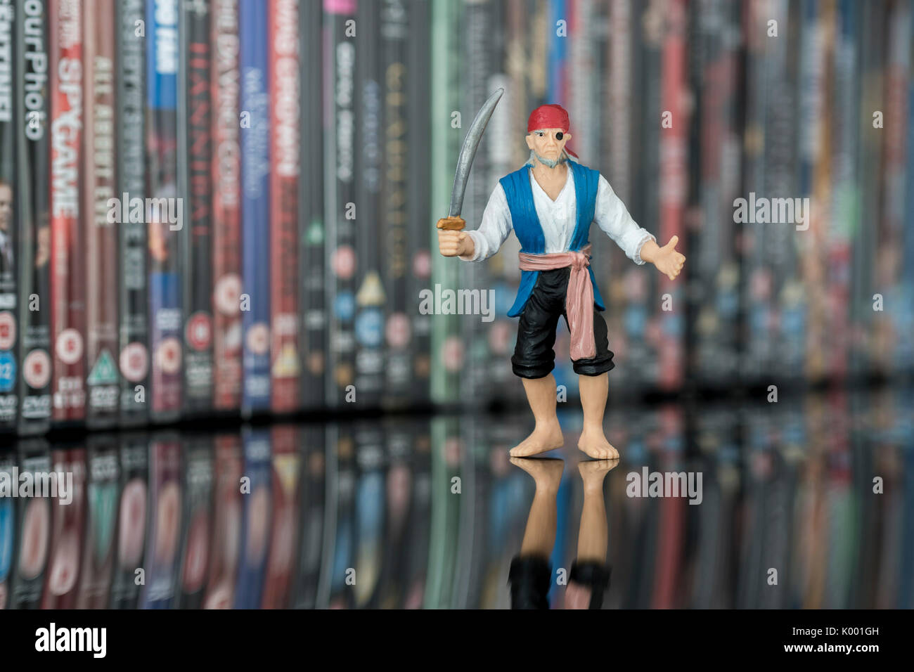 Sword wielding toy pirate standing in front of stacks of DVDs (Digital ...
