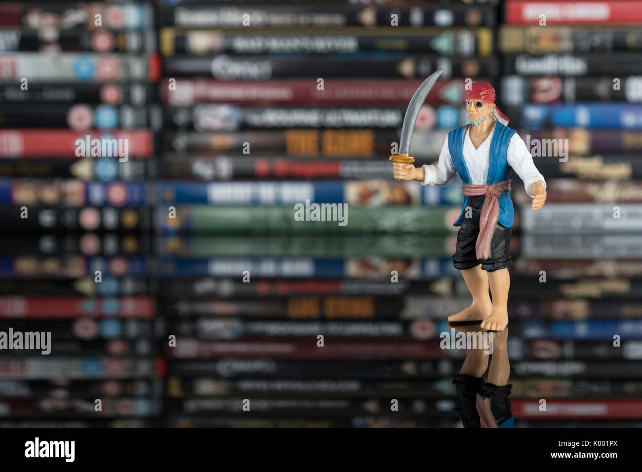 Sword wielding toy pirate standing in front of stacks of DVDs (Digital ...