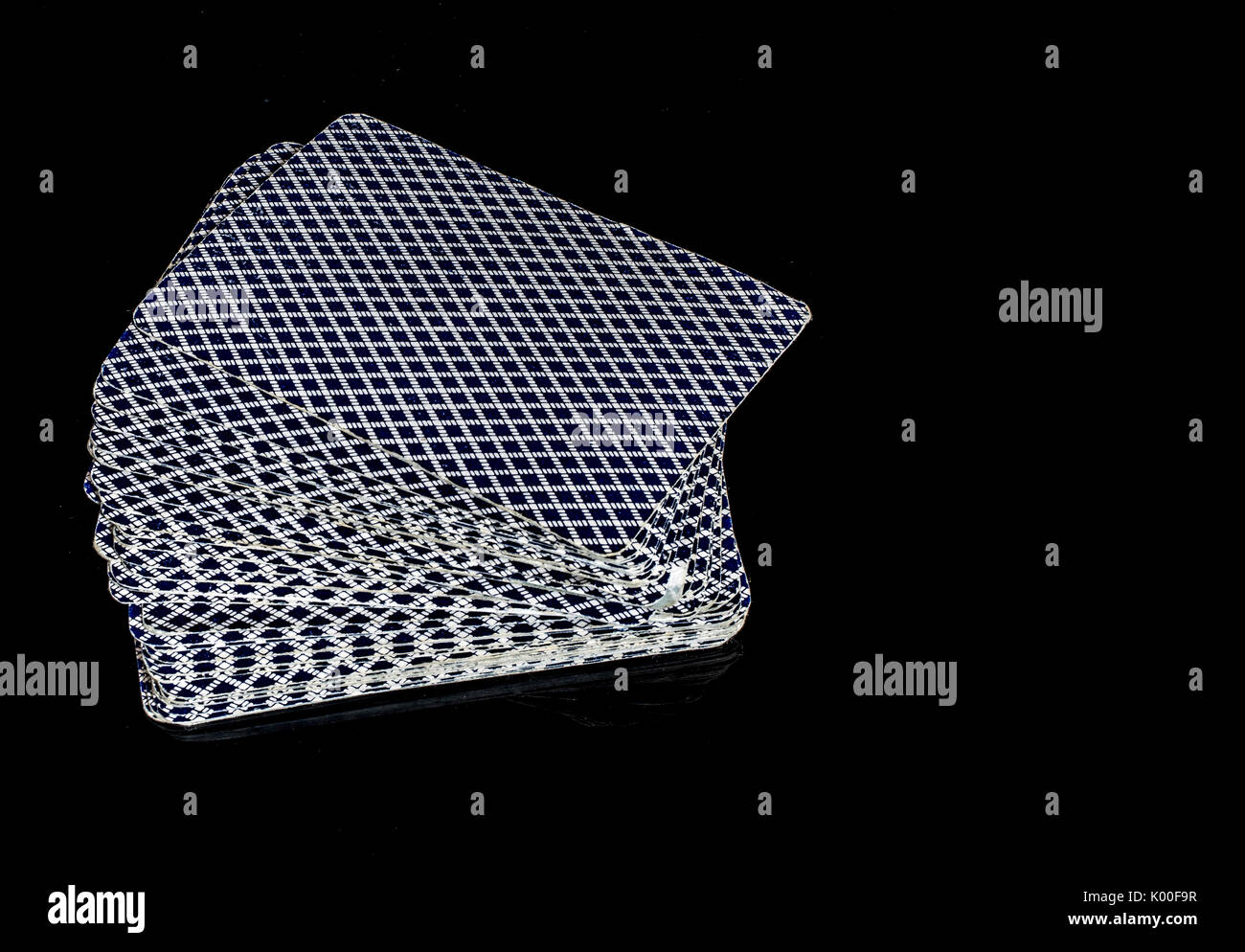 Spread playing cards deck, on a black reflective background, with ...