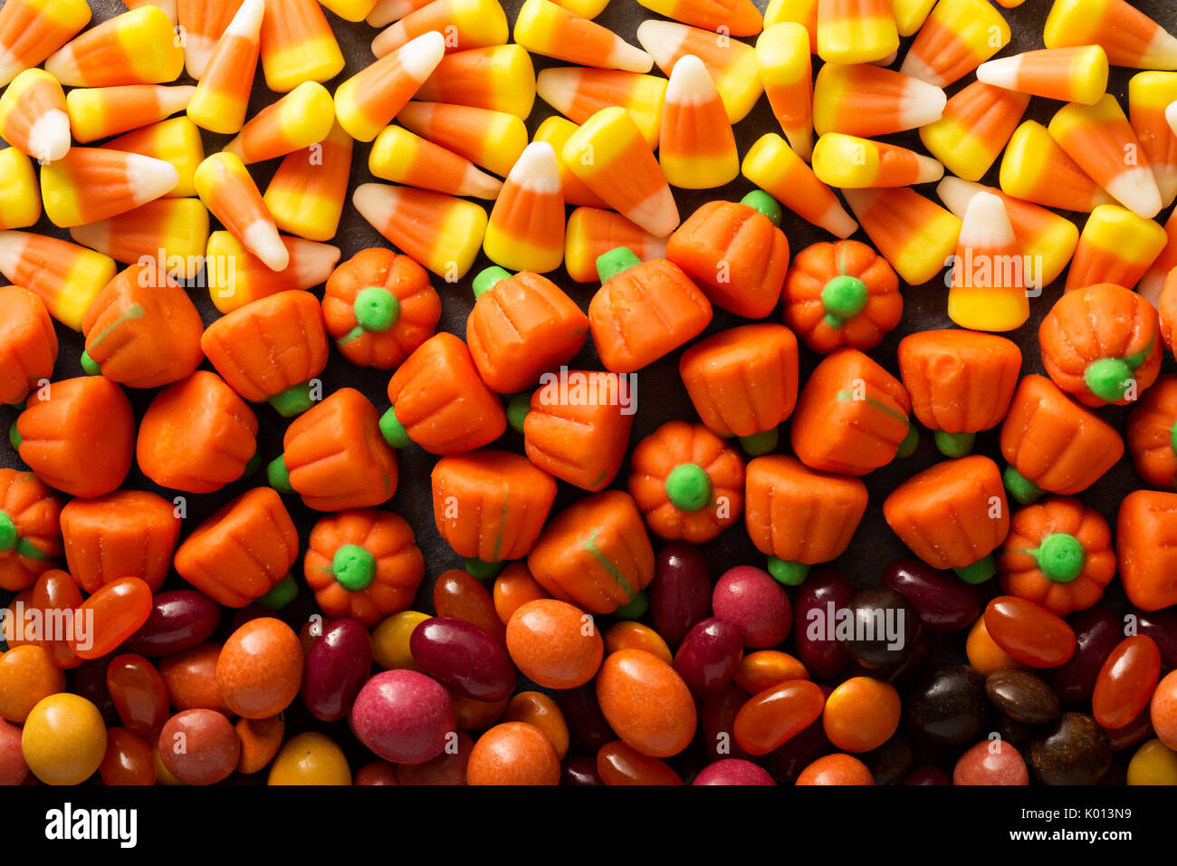 Candy corn and pumpkin Halloween background Stock Photo - Alamy