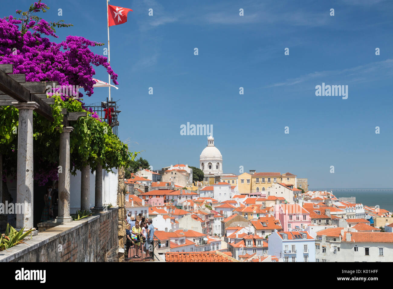 Flowers on a terrace frame terracotta roofs and the ancient dome at ...