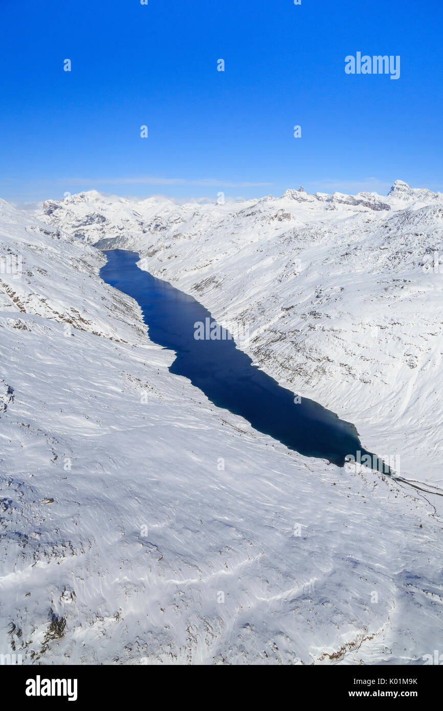 Aerial view of the alpine Lago di Lei surrounded by snow Val di Lei ...