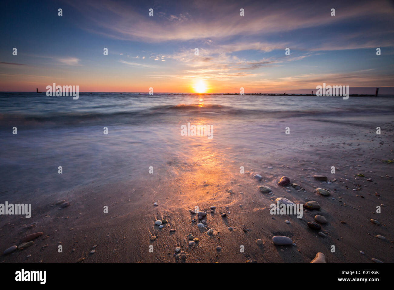 The lights of dawn are reflected on the sandy beach Porto Recanati ...
