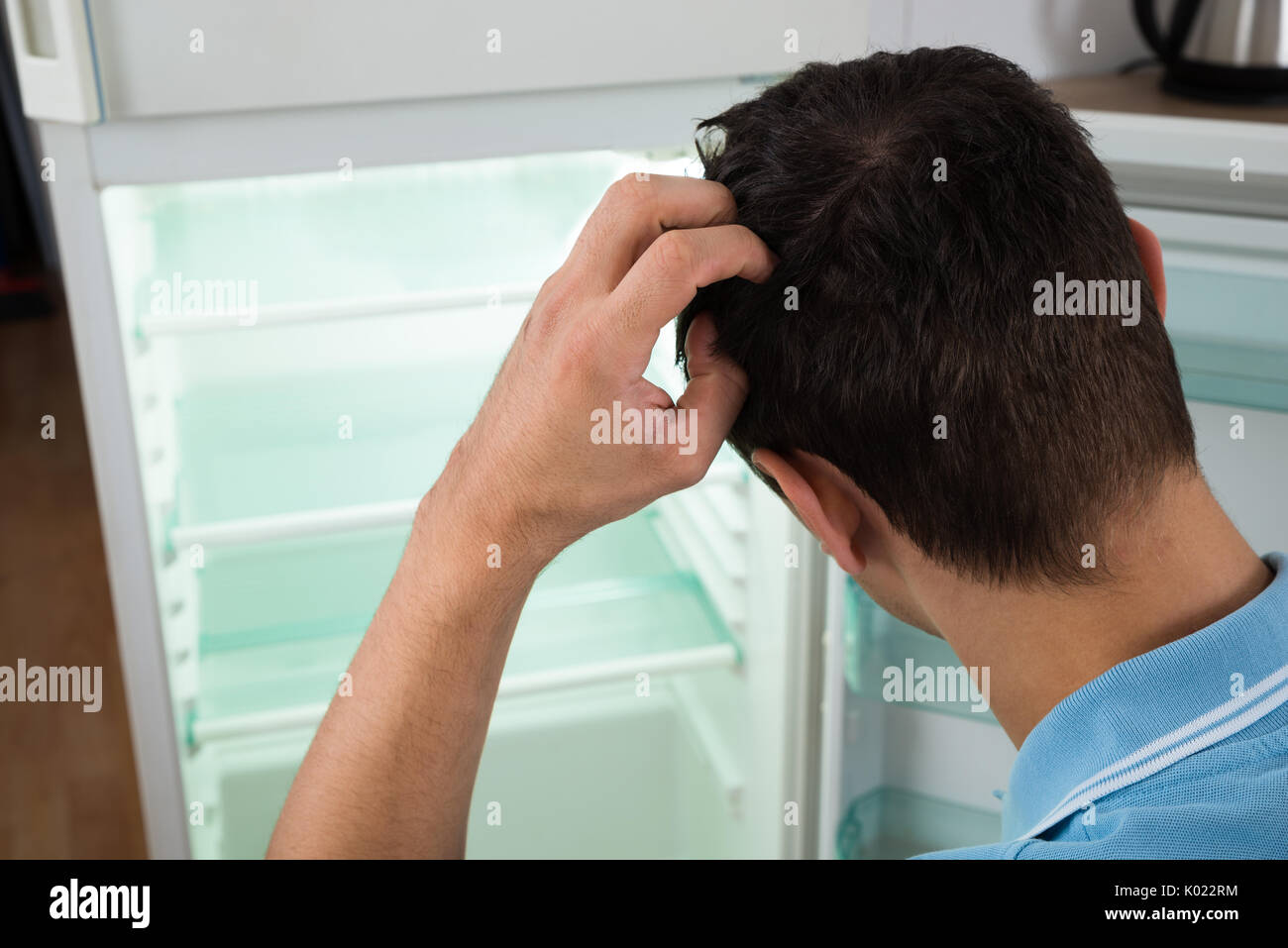 Rear view of confused man scratching head while looking at empty ... Rear view of confused man scratching head while looking at empty ...