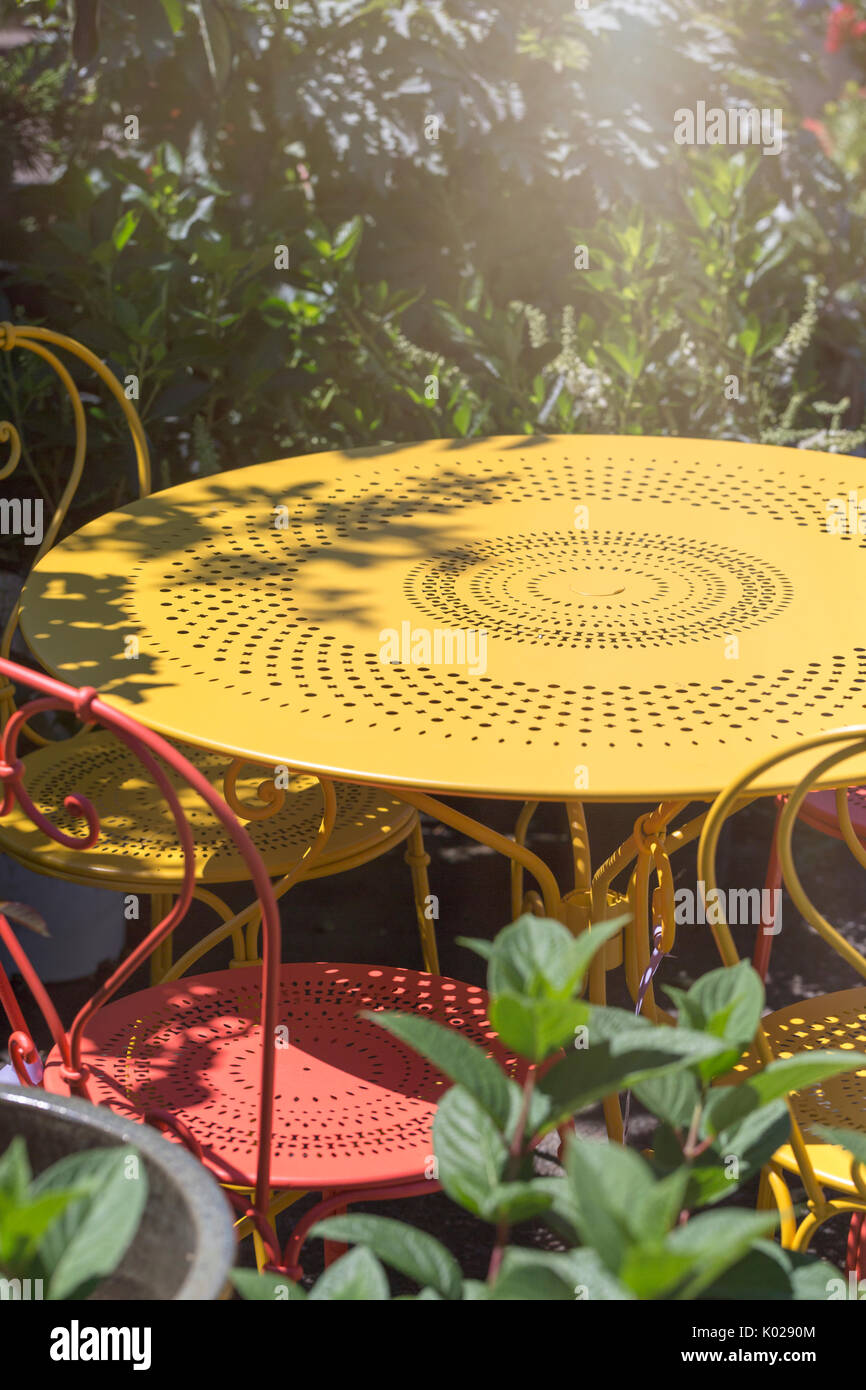 Colorful Patio Table sitting in a Summer Flower Garden Stock Photo - Alamy