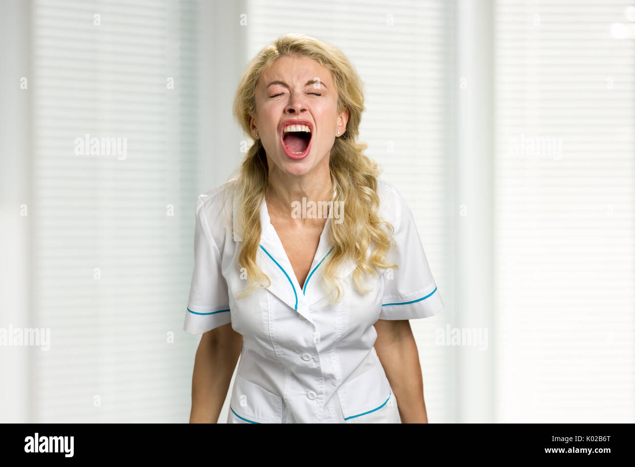 Young nurse screaming in despair. Very stressed beautiful young female ...