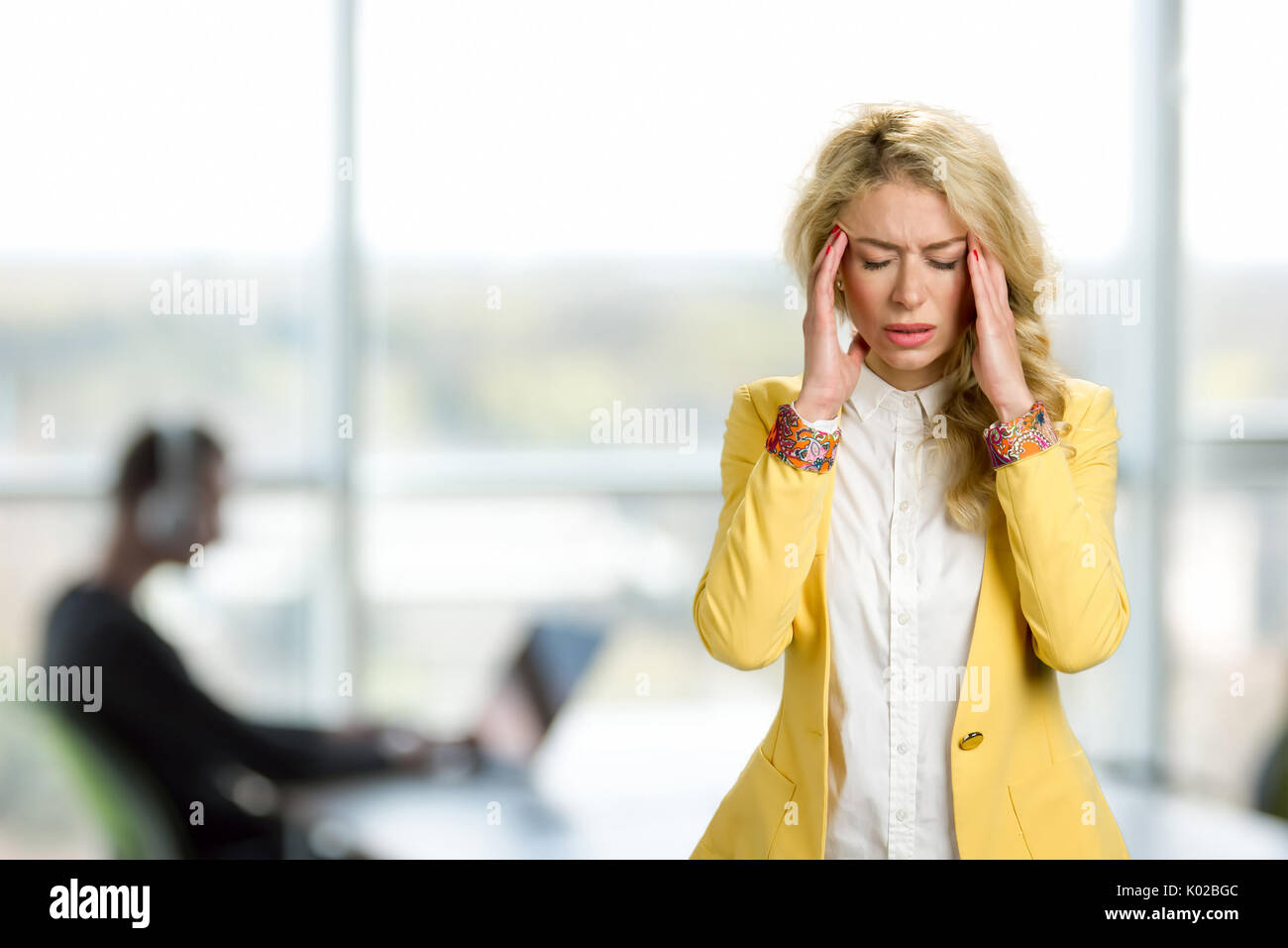 Young business woman with terrible headache. Depressed young manager ...
