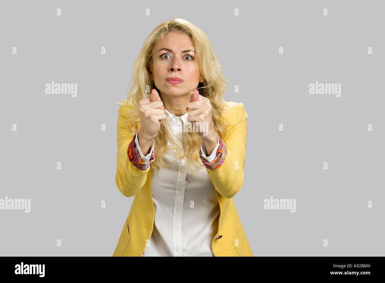 Angry young blonde gesticulating with thumbs. Aggressive angry woman ...