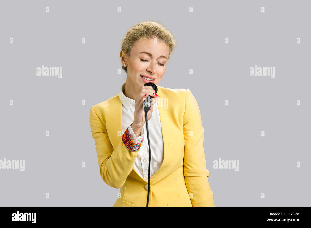 Beautiful young lady singing karaoke. Charming young woman singing into ...