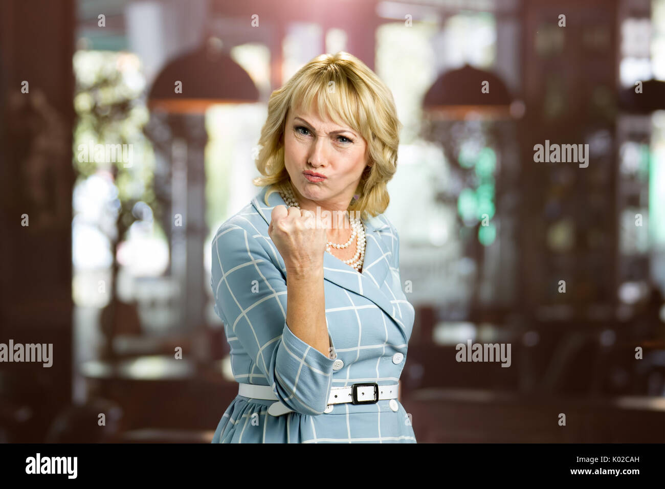 Aggressive mature woman putting up fist. Angry white-skin woman ...