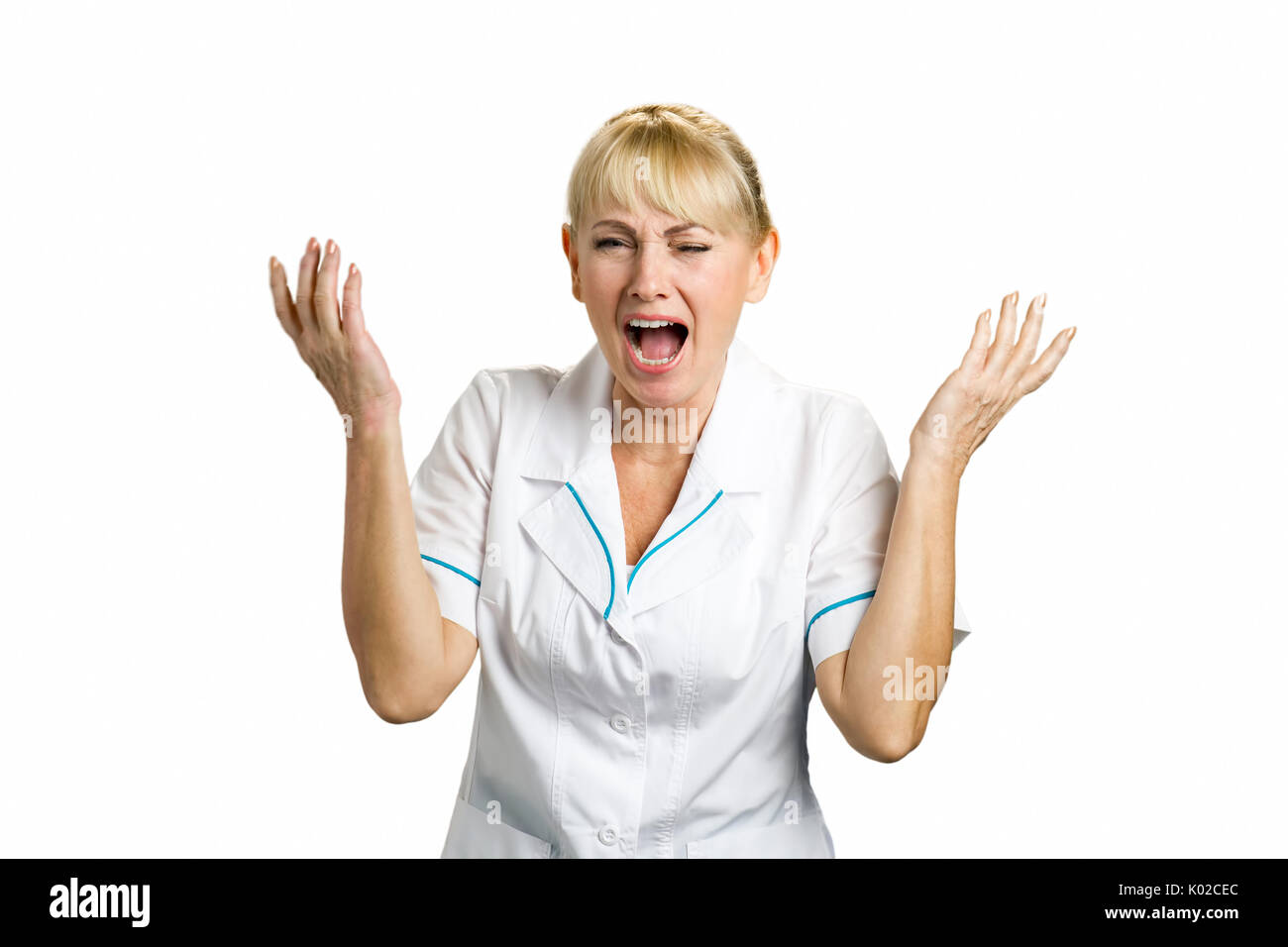 Screaming medical worker on white. Frustrated and shocked mature nurse ...