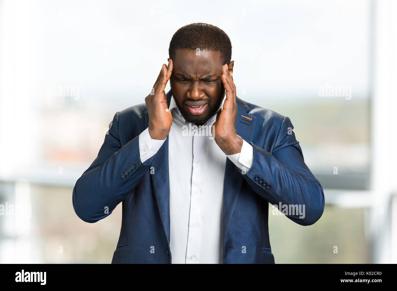 Young afro american businessman touching head. Black manager with upset ...