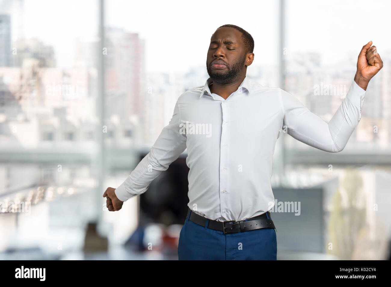 Sleepy businessman stretching in office. Young man stretched out his ...