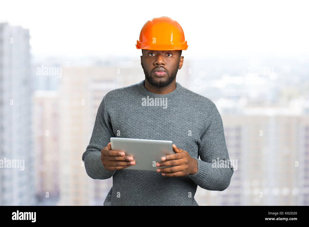 Man in safety helmet and computer tablet. Builder man working with a ...