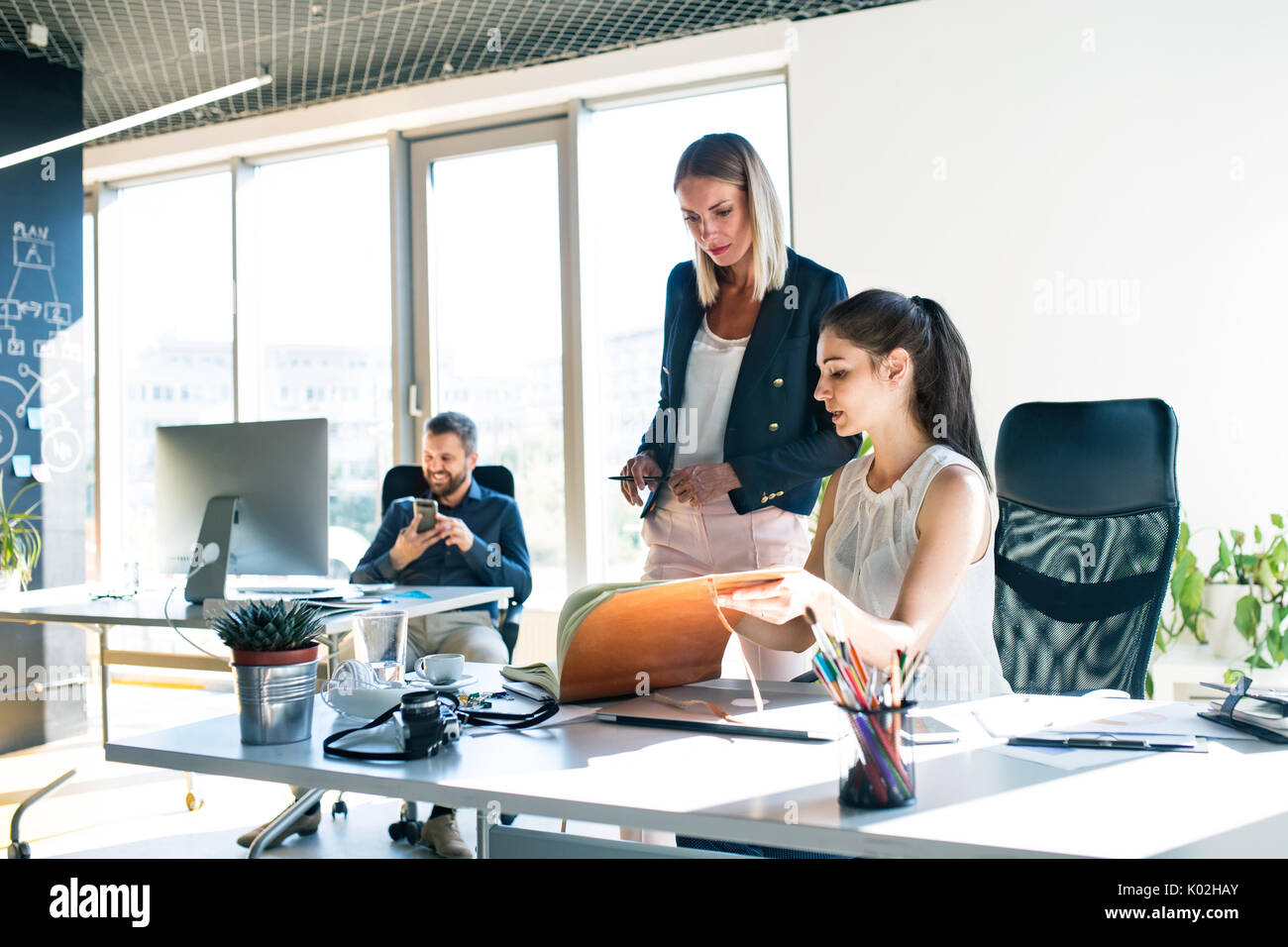 Three business people in the office working together Stock Photo - Alamy