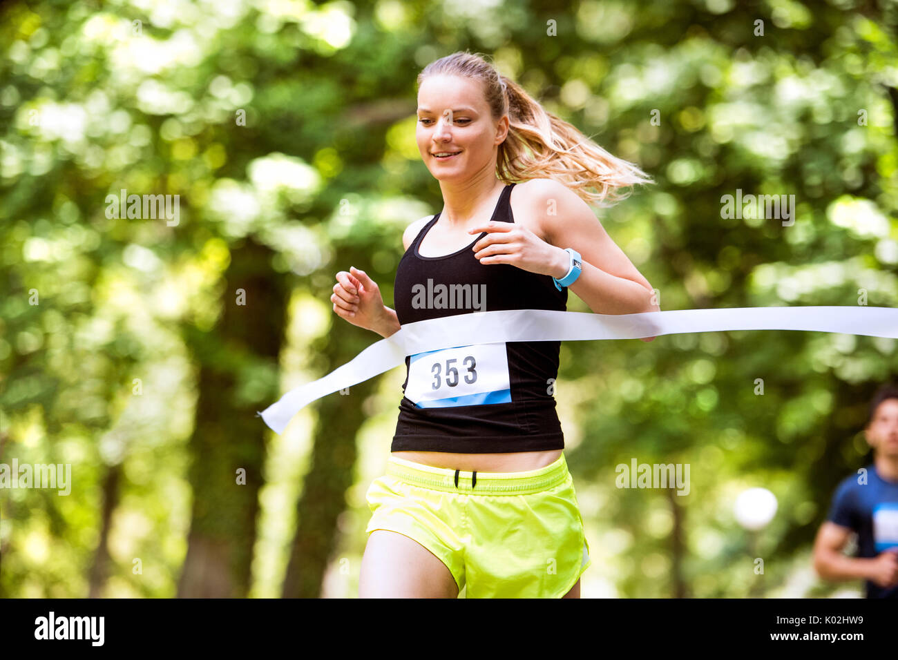 Young woman running the race crossing the finish line Stock Photo - Alamy