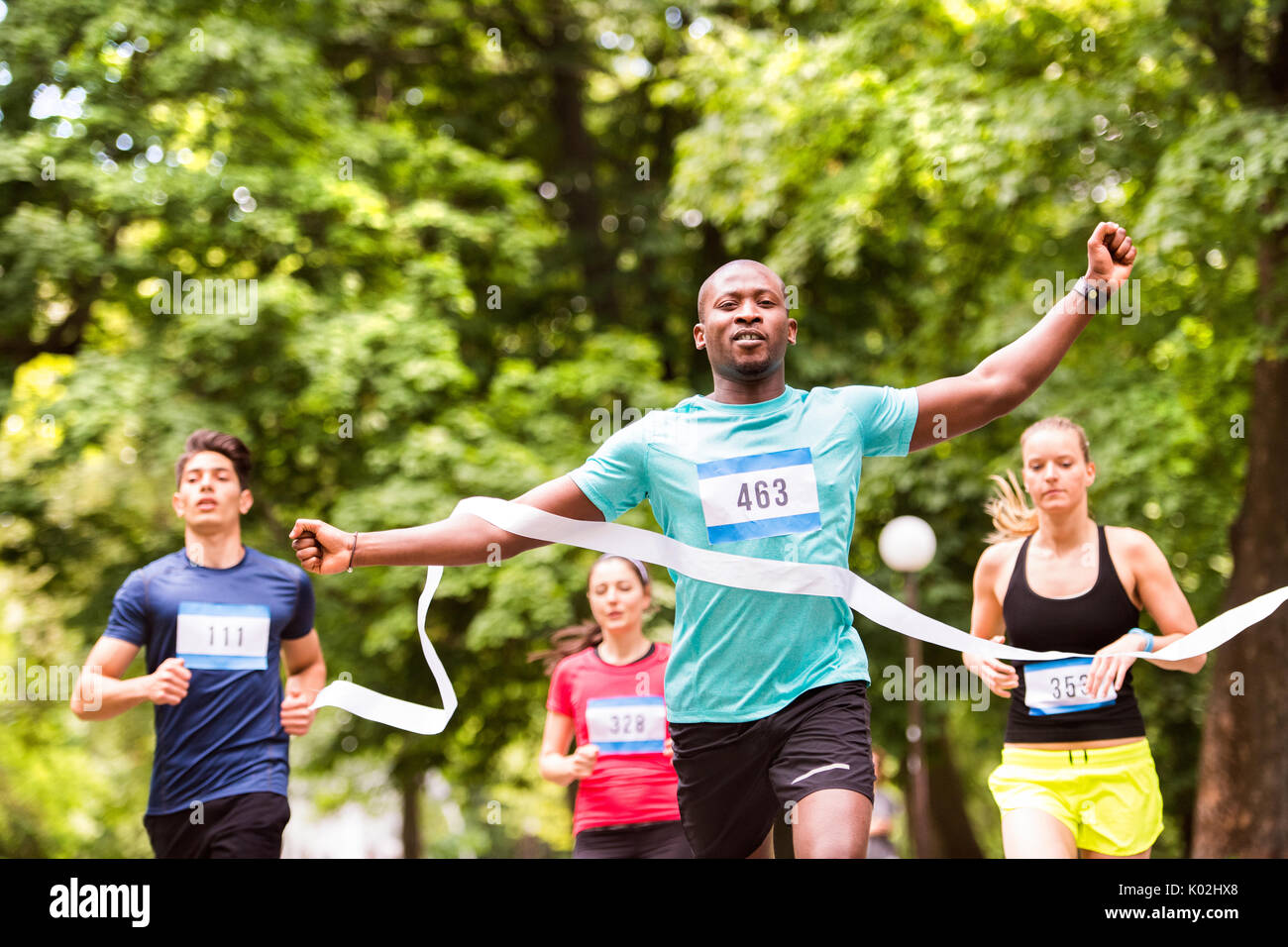 Young man running in the crowd crossing the finish line Stock Photo - Alamy