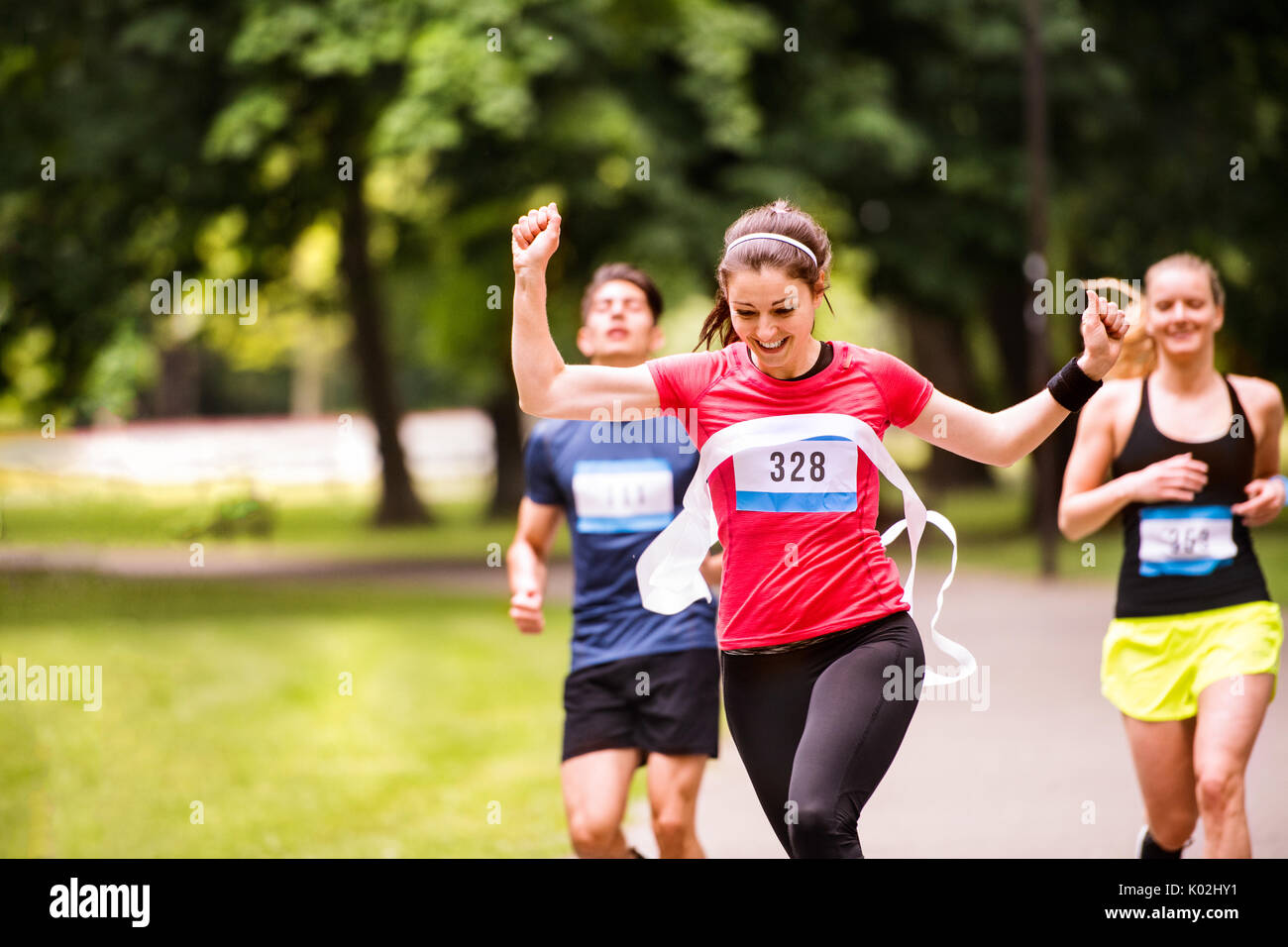 Young woman running in the crowd crossing the finish line Stock Photo ...