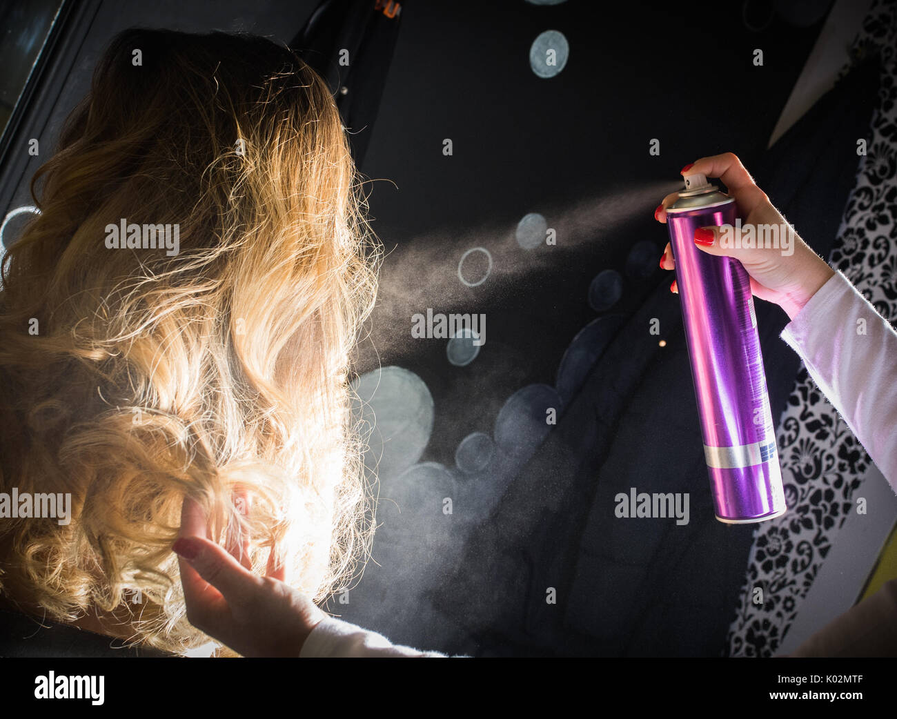 Hairdresser applying hair spray on ombre hair in beauty salon Stock ...