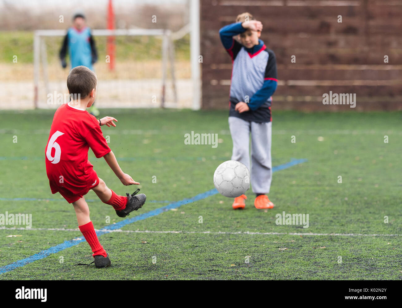 Boy kicking soccer ball hi-res stock photography and images - Alamy