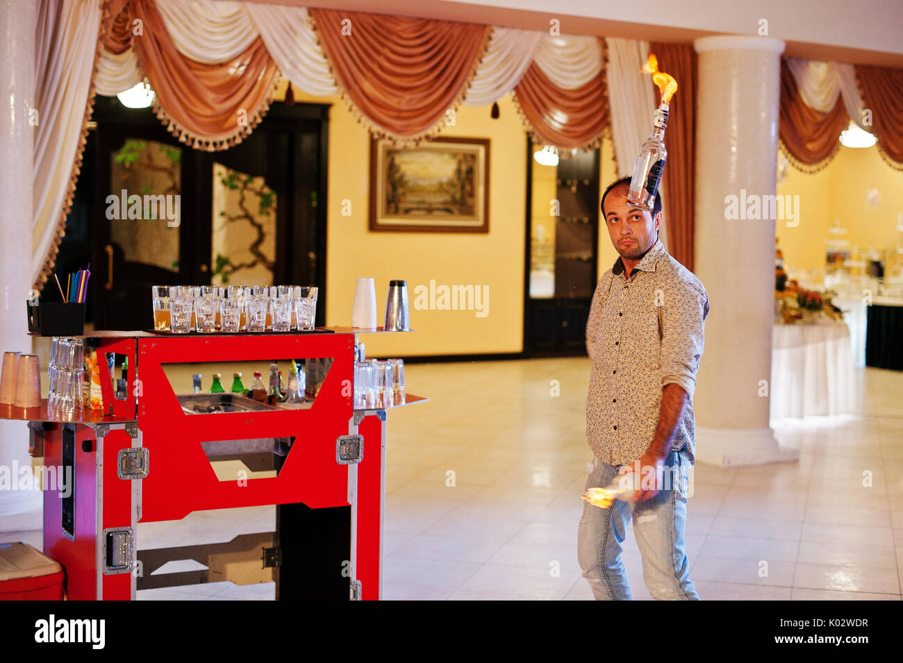 Skillful bartender performing bar tricks in front of a big audience on ...