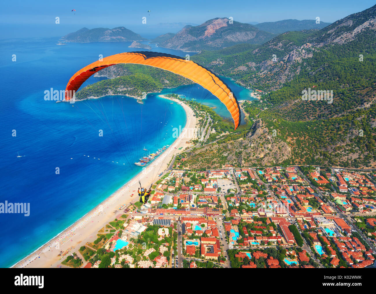 Paragliding in the sky. Paraglider tandem flying over the sea with blue ...