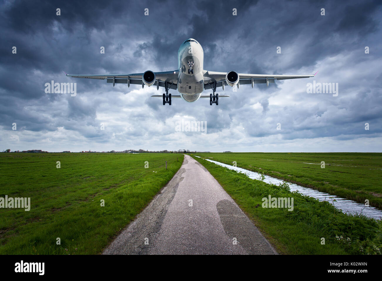 Airplane and country road. Landscape with passenger airplane is flying ...