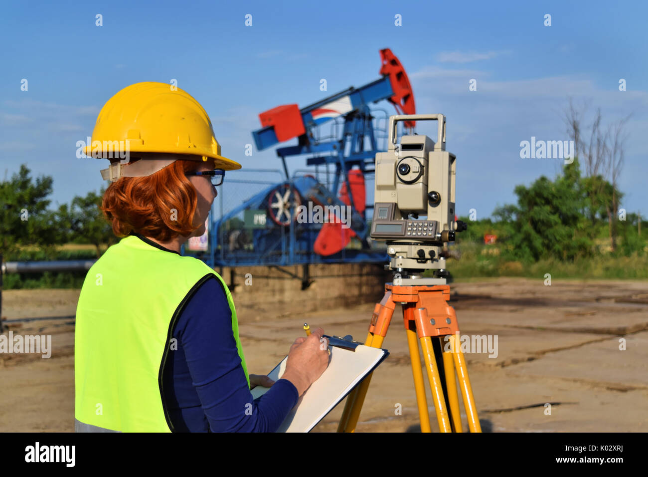 Surveyor at work and crude oil pump in background Stock Photo - Alamy