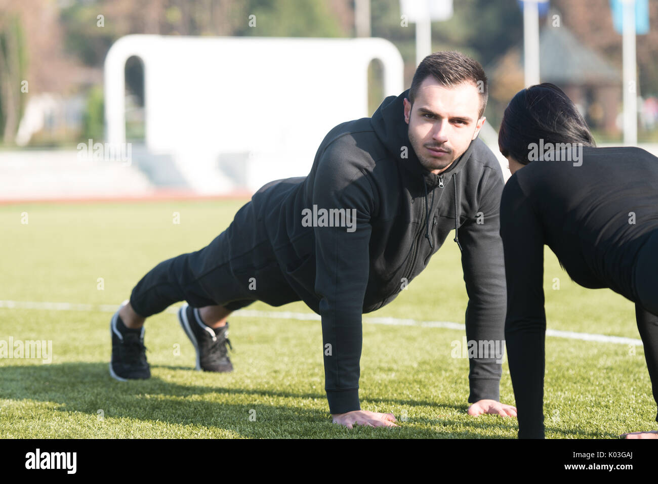 Attractive Couple Doing Push Up in City Park Area - Training and ...