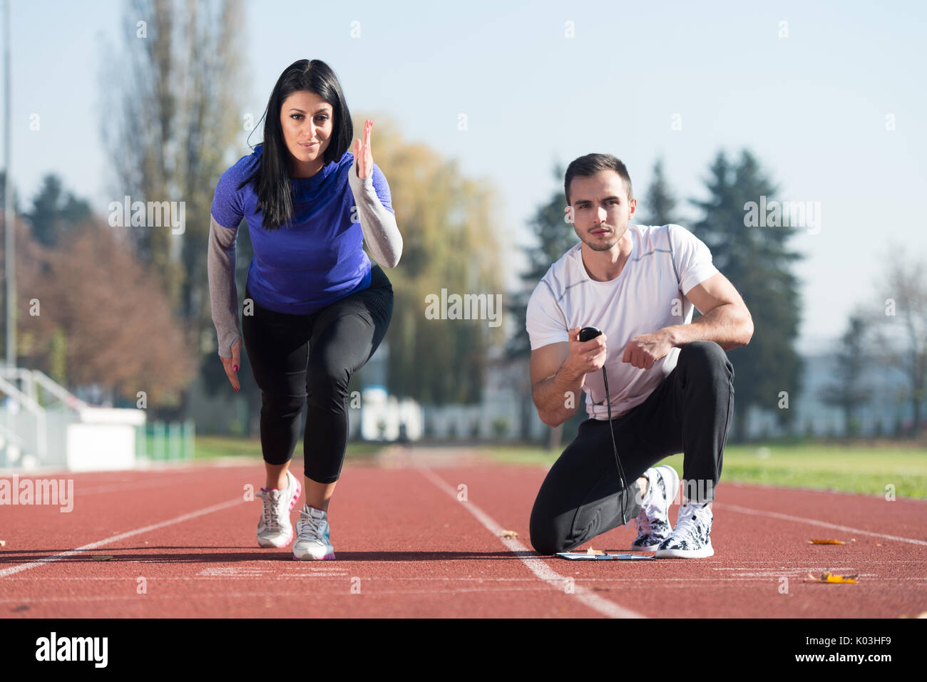 Handsome Personal Trainer Helping Woman To Sprint on the Running Track ...