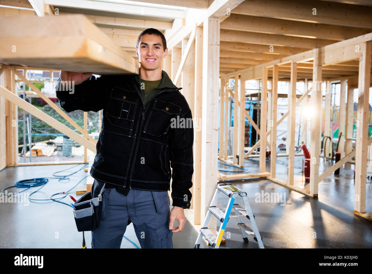 Male Carpenter With Wooden Plank At Construction Site Stock Photo - Alamy