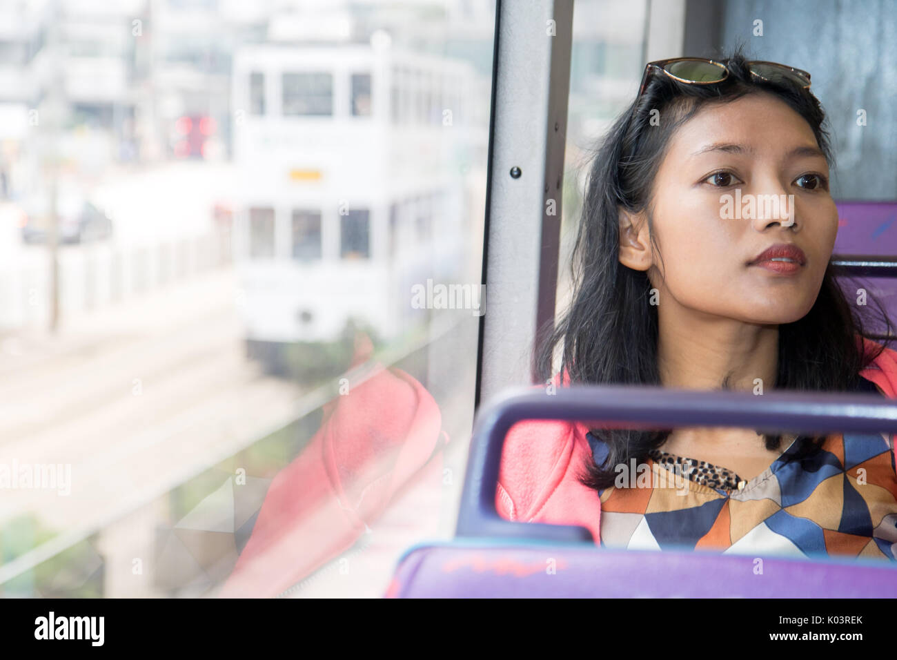 Young woman travels with a double-decker bus in the city center. The ...
