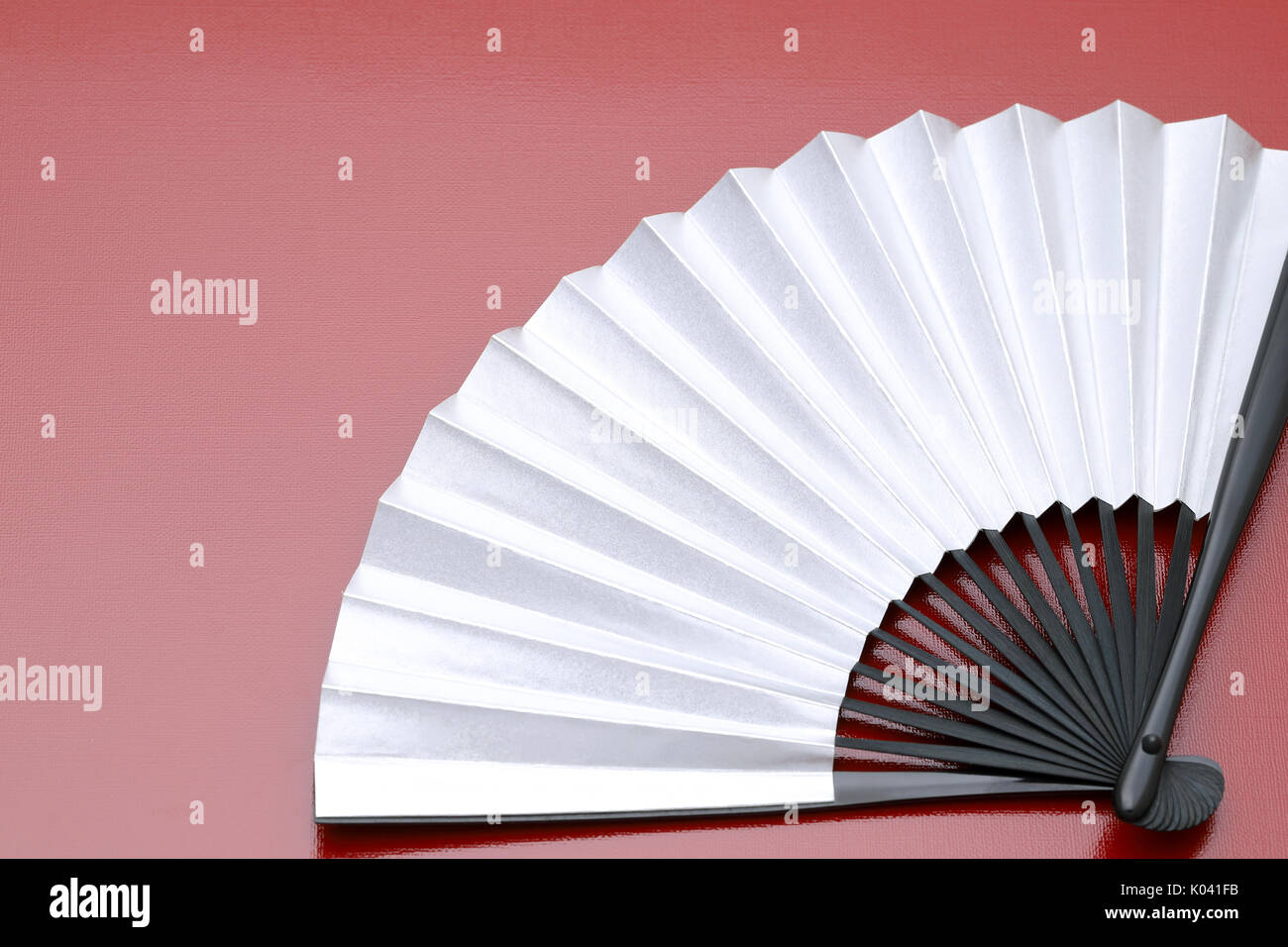 chinese style silver hand fan on red background Stock Photo - Alamy