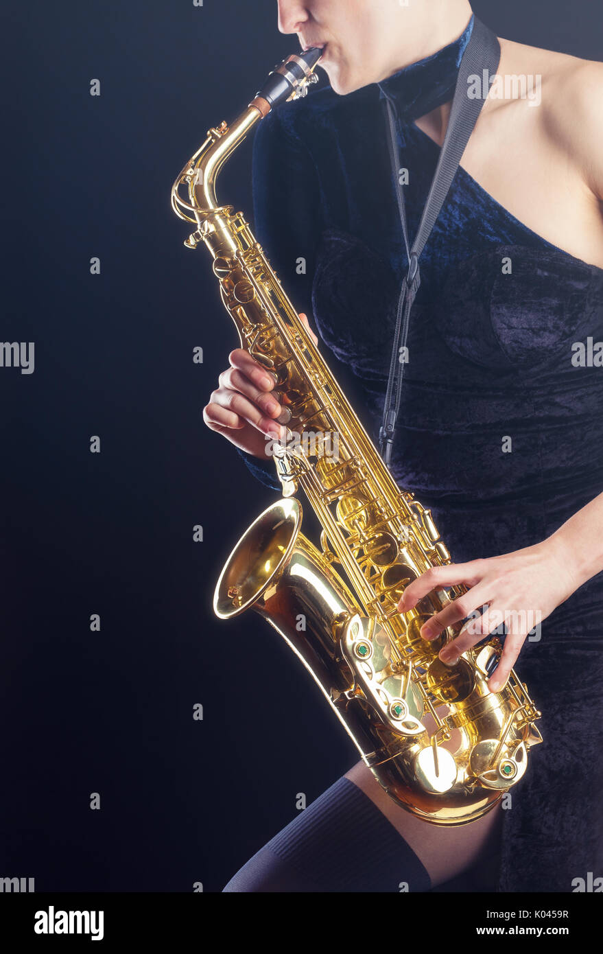 Saxophone player. Woman with saxophone on a dark background Stock Photo ...