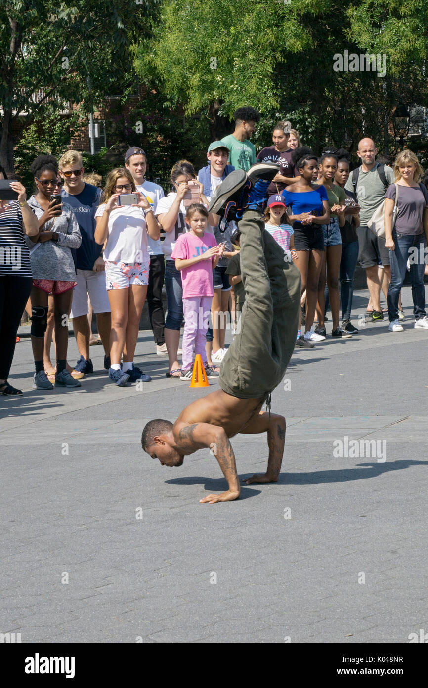 A shirtless acrobatic dancer performing for tips at Washington Square ...