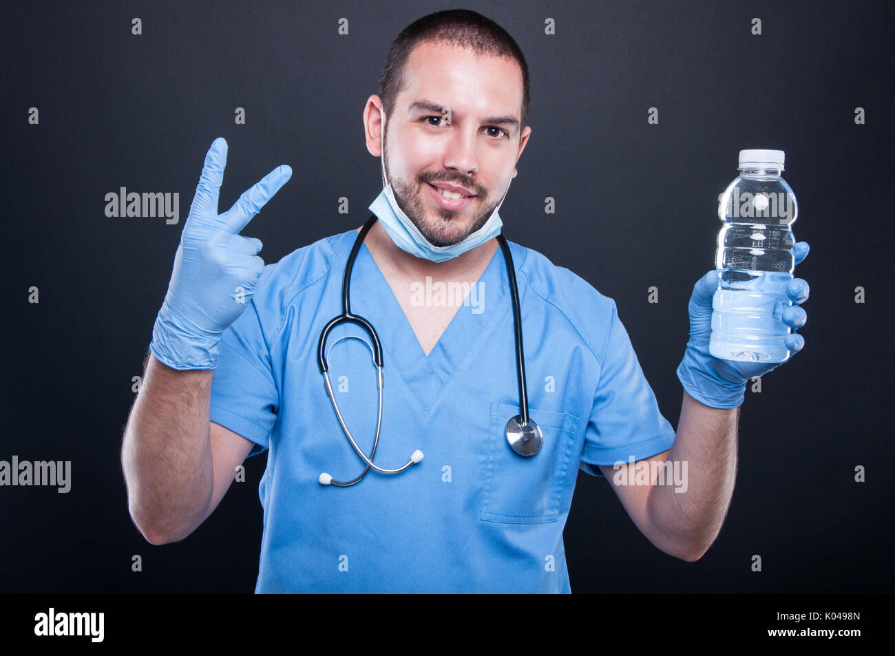 Medic wearing scrubs showing water and number two gesture on black ...
