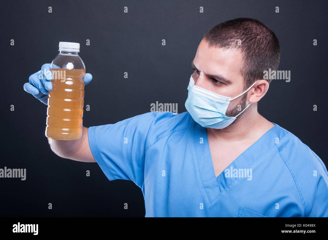 Medic wearing face mask holding not drinkable bottle of water like ...