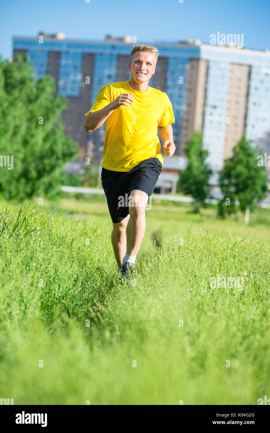 Sporty man jogging in city street park. Outdoor fitness Stock Photo - Alamy